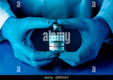A healthcare worker holding a Monkeypox vaccine vial next to a syringe ...