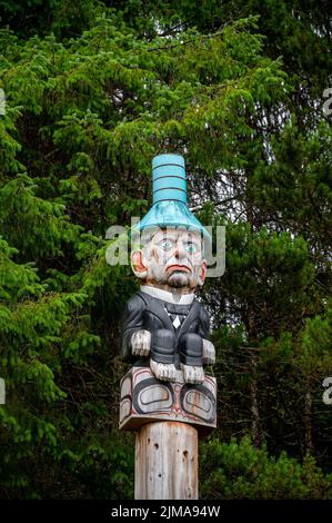 Tlingit totem pole with clan house in the background at the Totem Bight ...