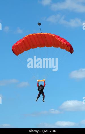 Parachutist floating to a square-shaped parachute Stock Photo - Alamy