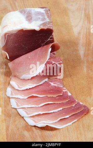 Cutting board with fried bacon rashers, rosemary and bowl of peppercorn ...