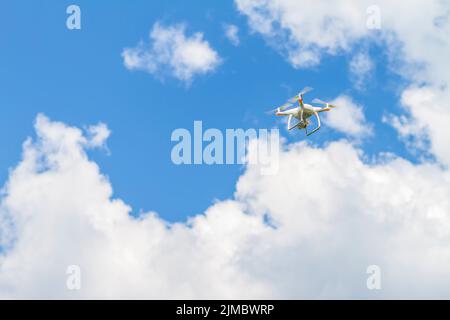 Photo of a flying white professional quadcopter drone camera in the air ...