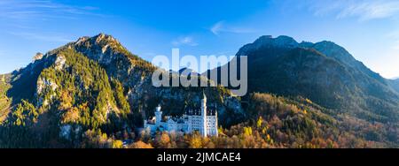 The palace of Neuschwanstein Castle behind autumn colourful trees with ...
