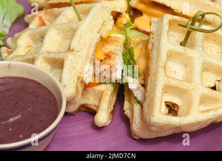 Belgium waffles with pan fried chicken on purple plate closeup Stock ...