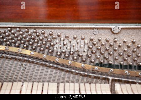 The inside of the piano is without a lid. Strings, hammers and other ...