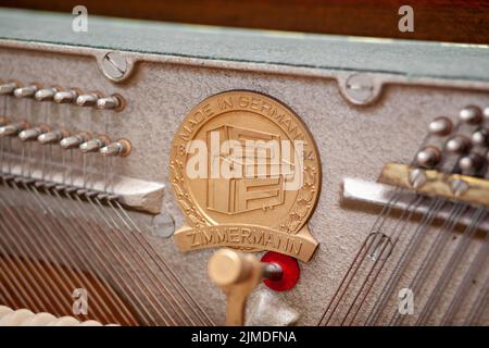 The inside of the piano is without a lid. Strings, hammers and other ...