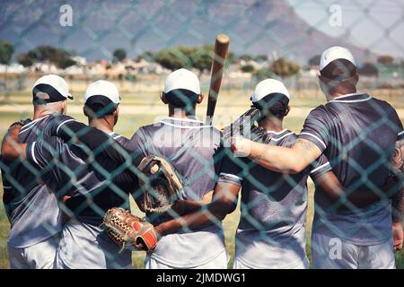 Bonded together by baseball. Rearview shot of a group of young men ...