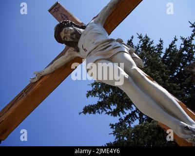 A sculptural image of the crucified Jesus Christ against a clear sky ...
