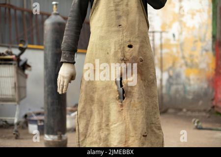 Old apron. Work clothes. Torn piece of cloth. Apron in holes. Details ...