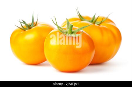Three Juicy organic yellow tomatoes, close-up, on a black background ...