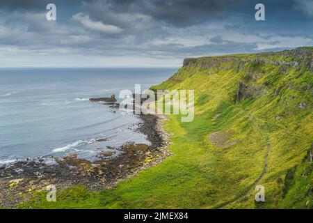Tourists on the path to The Amphitheatre in Giants Causeway, seen from ...