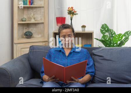 Senior asian planing retirement insurance health care contract on sofa ...