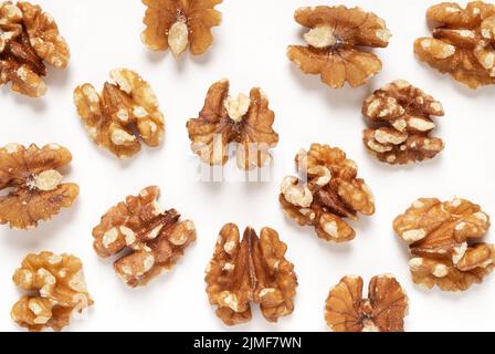 Halves of walnuts on scattered white background Stock Photo - Alamy
