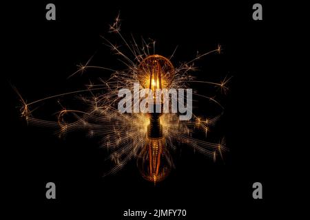 Burning sparkler behind a lightbulb Stock Photo - Alamy