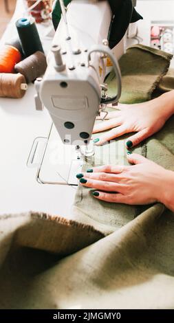 Unrecognizable cropped female dressmaker hands putting white soft ...