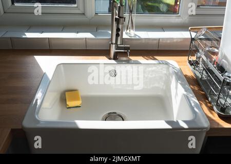 Beautiful white sink near window in modern kitchen Stock Photo - Alamy