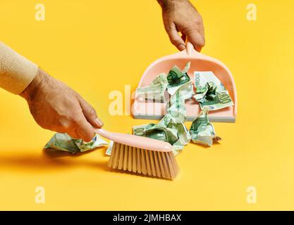 Creative layout with male hand sweeping money dollar bills on yellow ...