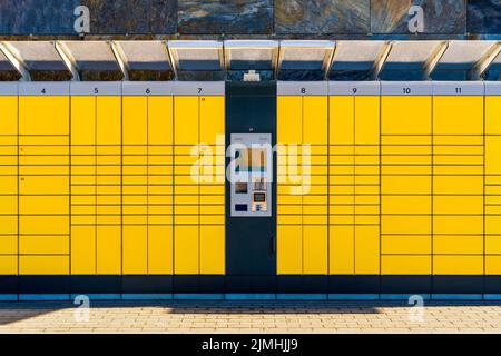 Yellow parcel pick up station or Packing station Stock Photo - Alamy