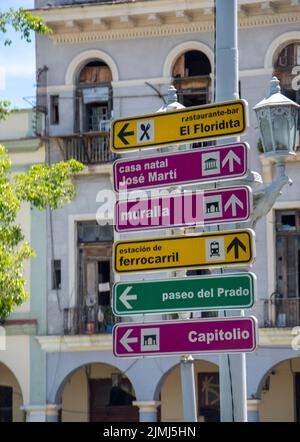 A pole with a list of signs showing various tourist sites in and around ...