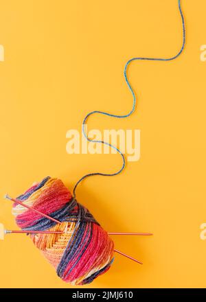 flat lay with yarn and knitting needles on beige backdrop Stock Photo ...