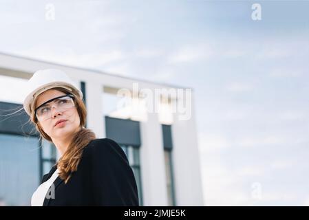 Young beautiful hispanic woman architect standing with serious ...