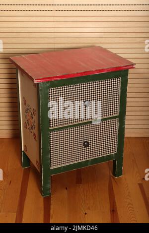 Chest of drawers with decor, coffee table and pouf near white brick ...