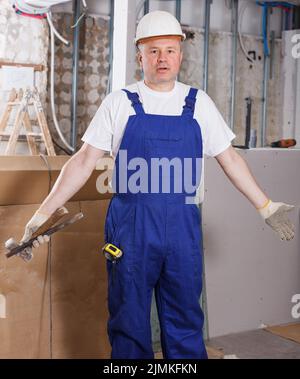 Perplexed worker inspecting room Stock Photo - Alamy