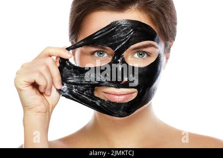 Beautiful woman is removing purifying mask from her face Stock Photo ...