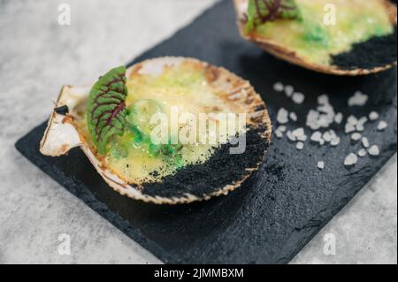 Delicacy roasted scallops with cheese spices and chuka algae Stock ...