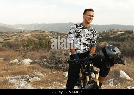 Smiling professional downhill rider and his bicycle Stock Photo - Alamy