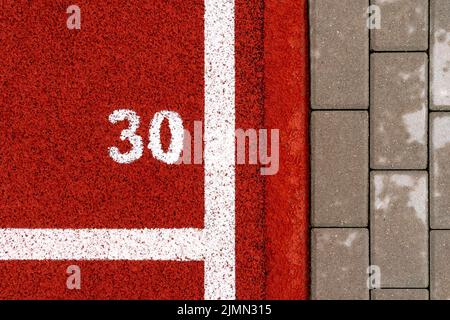 Sidewalk near the running track with 30m mark Stock Photo - Alamy