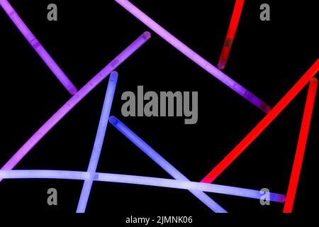 Purple blue red neon straws dark background Stock Photo - Alamy