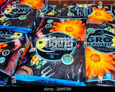 A stack of bags of Growmore Seaweed Compost in a farm shop in North ...