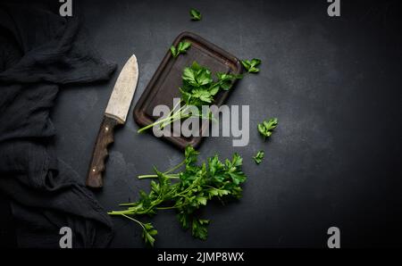 Parsley sprigs on wooden cutting board Stock Photo - Alamy