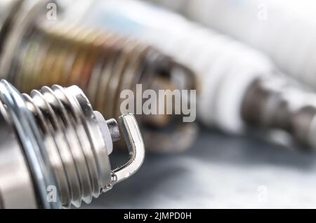 New and used spark plugs for internal combustion engine on metal ...