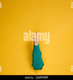 Woman points finger to wrist in studio against blue background while ...