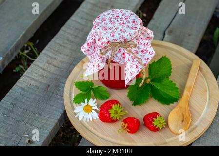 one jar of strawberry jam stands on a board Stock Photo - Alamy