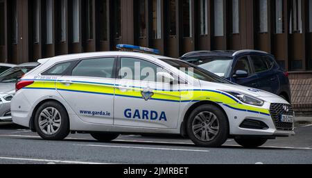 Garda, description on police car, with yellow and blue stripes on sides ...