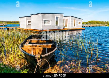 Floating fishing cabins on the blue water of a park lake Stock Photo ...