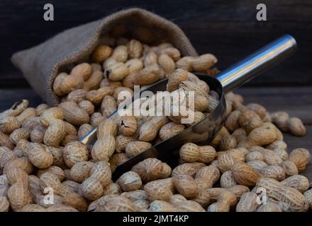 Bag and shovel bucket with bulk peanuts Stock Photo - Alamy