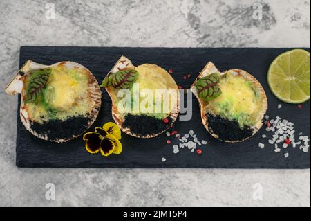 Delicacy roasted scallops with cheese spices and chuka algae Stock ...