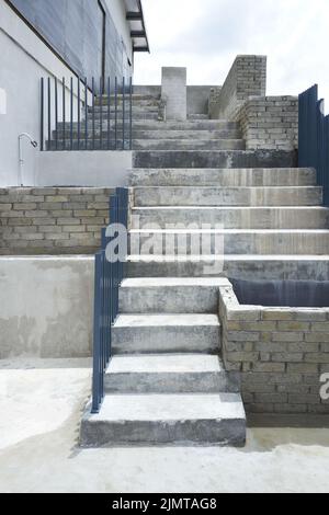 Old concrete structure with weathered staircase and cracks in bright ...