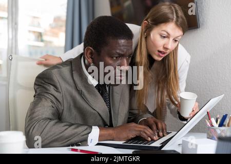 Young female boss communicating with her subordinate in open-plan ...