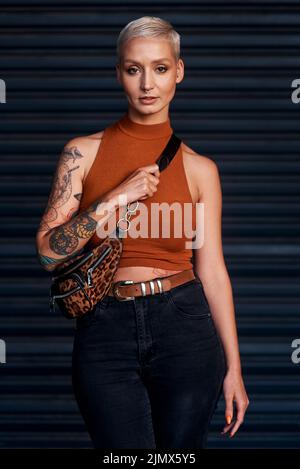Young blonde woman standing with serious expression over isolated pink ...