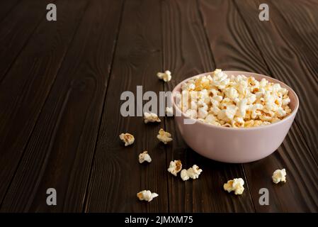 Bowl with popcorn on dark wooden table with copy-space Stock Photo - Alamy