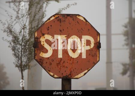 stop sign old rusty morning in the fog in the city of Dnipro drove ...