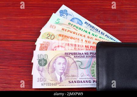 Philippine peso in the black wallet Stock Photo - Alamy