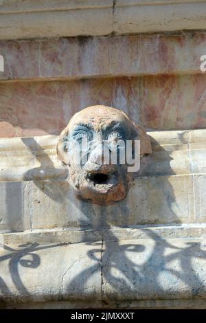 A gargoyle in shape of a human face of the water fountain built in 1903 ...