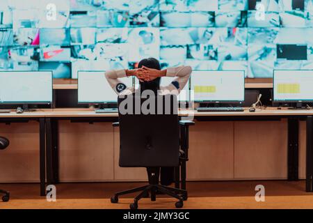 Female security operator working in a data system control room offices ...