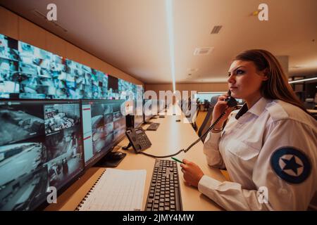 Female security guard operator talking on the phone while working at ...