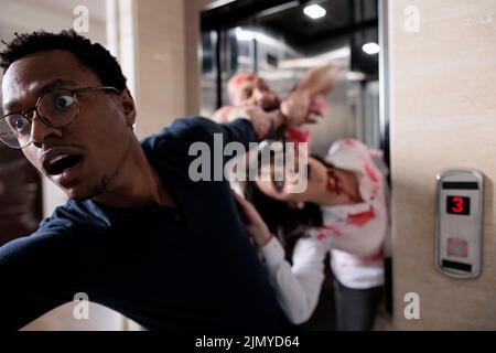 Brain eating zombies chasing frightened man in business office, looking ...